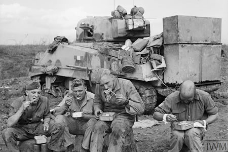 The crew of a Sherman tank fitted with deep wading equipment enjoy an ...
